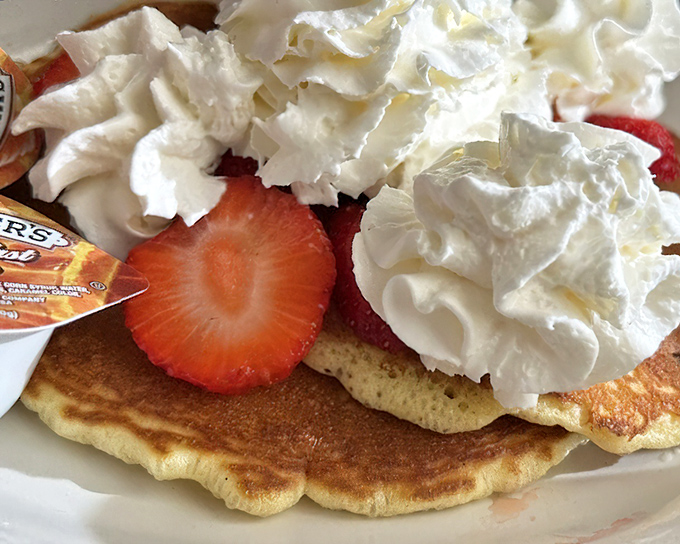 Pancake perfection isn't just about the fluff factor &ndash; it's the canvas of golden brown topped with fresh strawberries and clouds of real whipped cream.