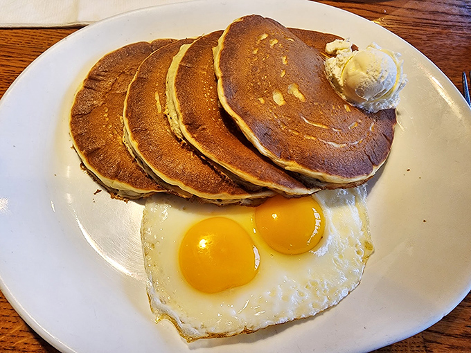 Pancakes stacked like golden vinyl records of deliciousness, with sunny-side eggs playing backup. This breakfast hits all the right notes.