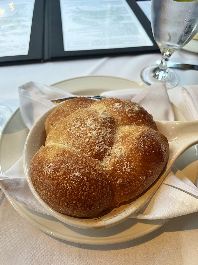 Not just bread—a warm, golden parmesan-dusted cloud that makes you question why you ever considered saving room for the main course.