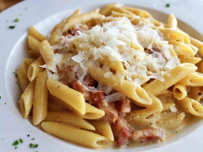 Carbonara: where bacon and pasta perform their beautiful dance. Creamy, cheesy penne with pancetta that's worth every carb-laden bite.