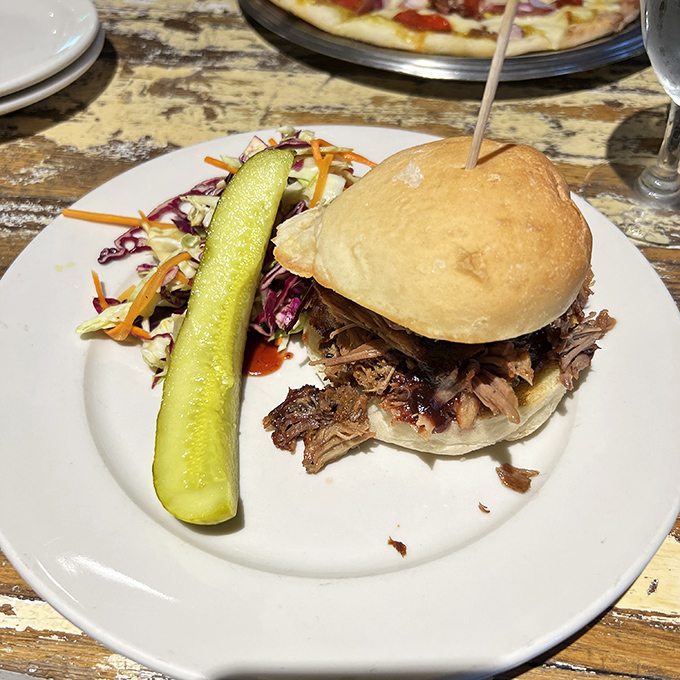 A pulled pork sandwich that doesn't need fancy tricks&mdash;just honest flavor, a pickle spear standing guard, and slaw for contrast.