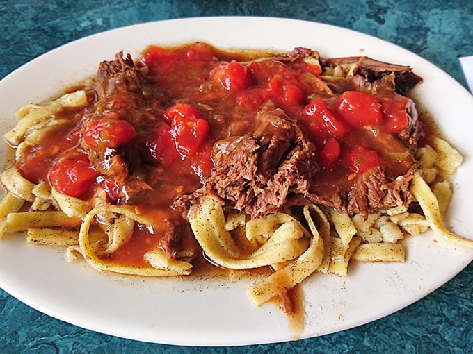 Homestyle butter noodles topped with pot roast and stewed tomatoes&mdash;proof that sometimes the most unforgettable meals aren't trying to be Instagram famous.
