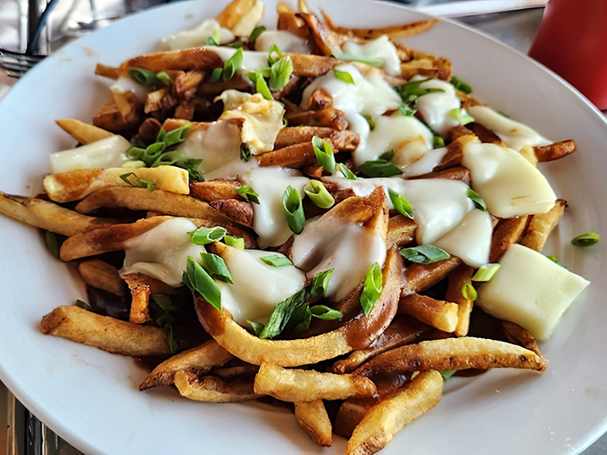 Poutine with melted cheese and green onions brings a touch of indulgent comfort to the desert. Like a warm hug on a plate, if hugs were deliciously caloric.