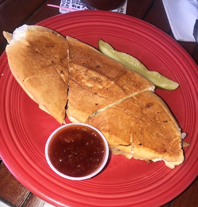 A pressed sandwich that would make Cuban grandmothers nod in approval, served with a pickle spear for that perfect tangy counterpoint.
