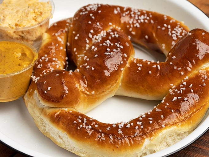 This isn't just any pretzel &ndash; it's architectural genius with carbs. The accompanying dips aren't sidekicks; they're equal stars in this show.