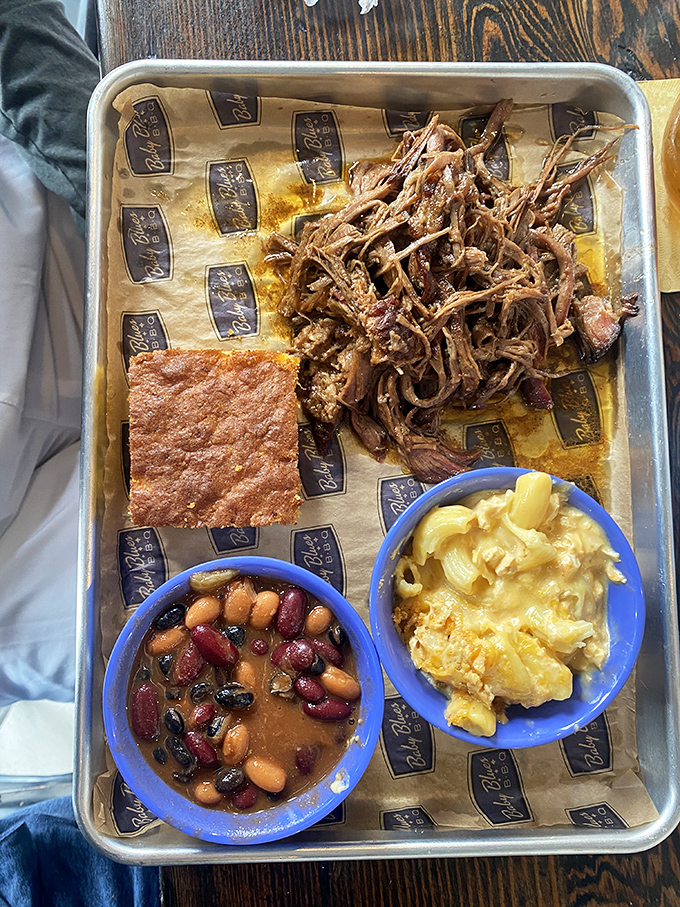 A tray of pulled pork flanked by beans and mac – proof that sometimes the best things in life come on wax paper.