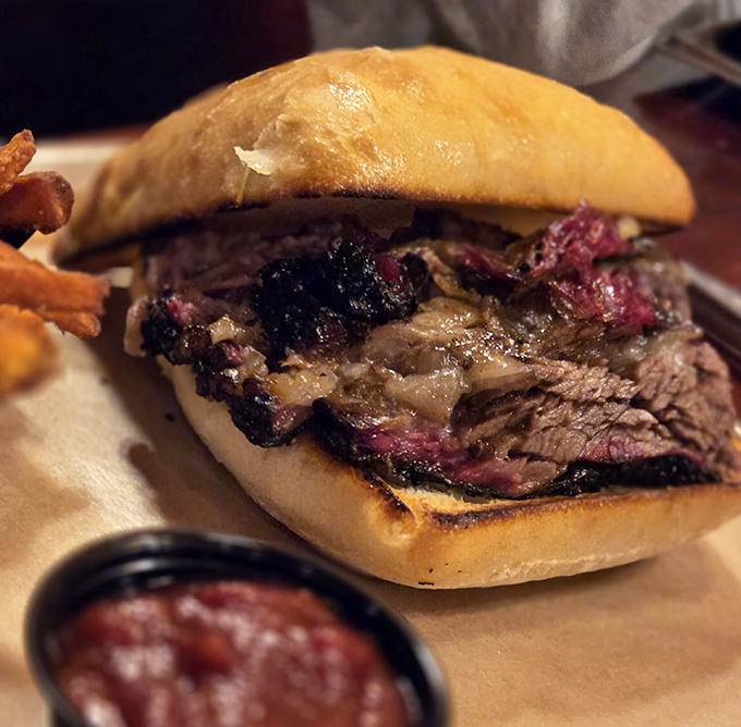 Architecture that makes sense: sturdy bun foundation supporting a masterpiece of smoked brisket. The sauce cup stands ready for customization.