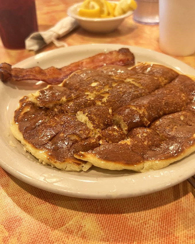 Pancakes so perfectly golden they should come with their own trophy, accompanied by bacon that knows exactly what it's doing. 