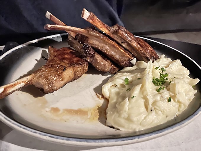 These lamb chops aren't just dinner; they're edible architecture, standing tall beside cloud-like mashed potatoes that could make a Frenchman weep.