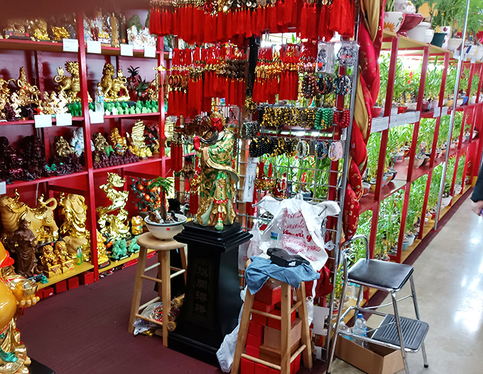 A dazzling display of golden statues and spiritual items creates a cultural crossroads where faith meets artistry in vibrant, eye-catching arrangements.