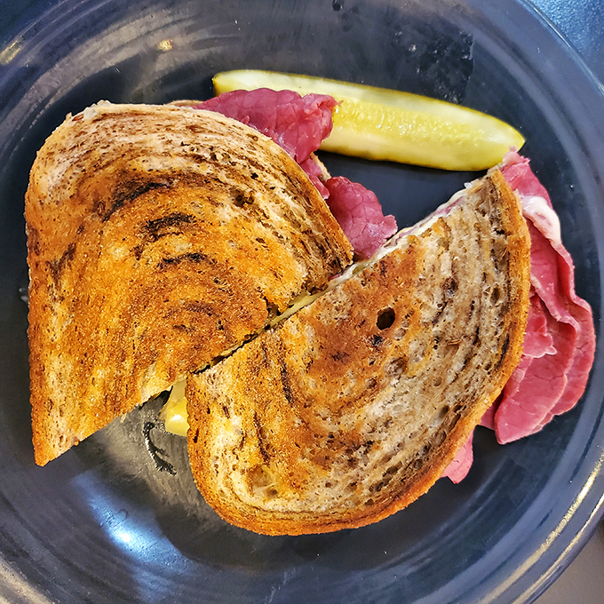 This isn't just a sandwich; it's architecture. Perfectly toasted bread, melty cheese, and that pickle spear standing guard like a delicious sentinel.