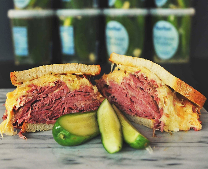 The Reuben: where corned beef, sauerkraut, and Swiss cheese perform a perfectly choreographed dance. Those pickles standing guard? Essential supporting characters.