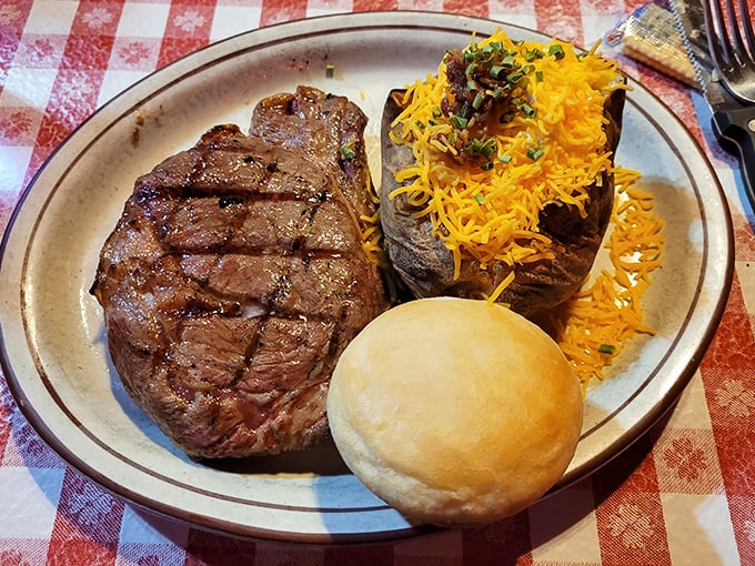 A perfectly grilled ribeye with a loaded baked potato &ndash; proof that sometimes the simplest pleasures require the biggest plates.