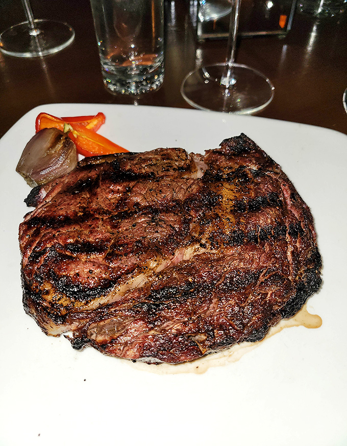 A ribeye with the kind of char marks that deserve their own Instagram account, flanked by roasted vegetables standing at attention.