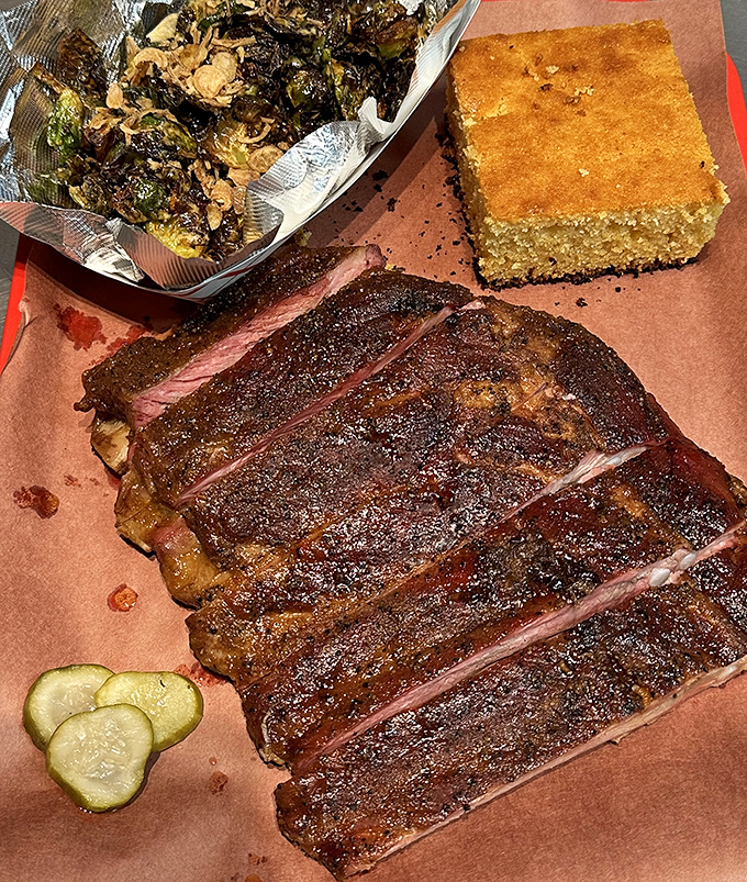 Ribs with a bark so perfect it deserves its own Instagram account, served with Brussels sprouts that might actually convert vegetable skeptics.