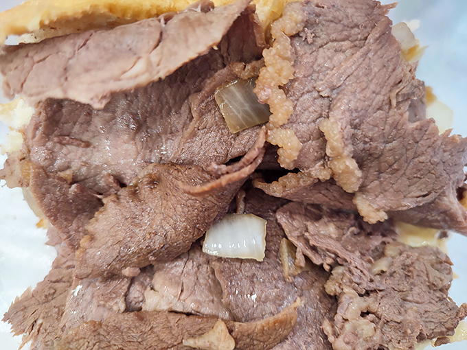 Layers of thinly sliced beef with just the right amount of onions – proof that sometimes the simplest combinations create the most profound flavors.