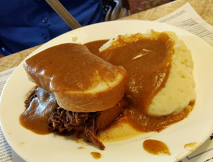 The hot roast beef sandwich&mdash;where bread becomes a throne for tender meat, and gravy flows like delicious lava across a landscape of mashed potatoes.