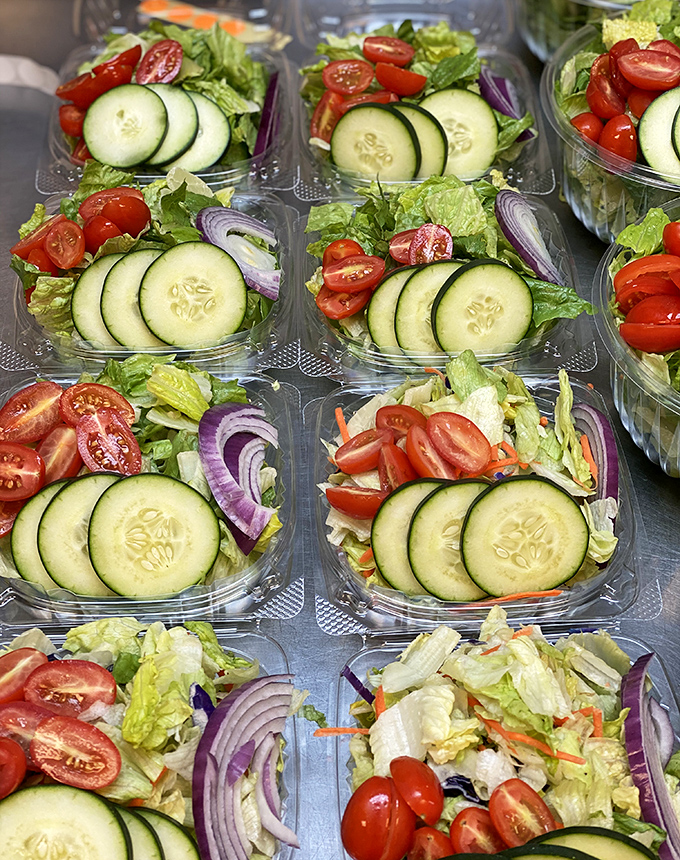 Fresh salads lined up like colorful soldiers, ready to balance out all that delicious crab indulgence.
