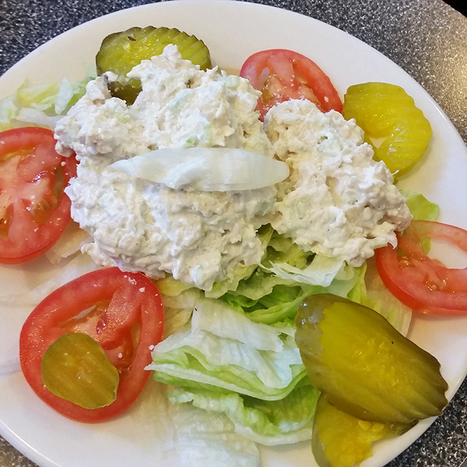 A chicken salad plate that proves simplicity still reigns supreme. Those pickle chips aren't just garnish; they're essential supporting characters.