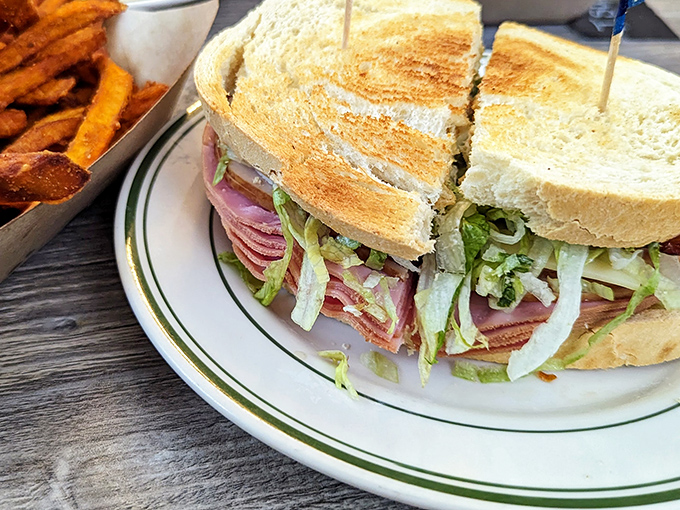 This isn't just a sandwich; it's architectural genius with layers of meat and veggies stacked between toast that somehow defies the laws of structural engineering.