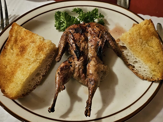 The quail arrives splayed and glorious, flanked by golden garlic bread&mdash;proof that the Hitching Post's magic extends beyond beef.
