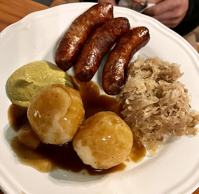 Plump German sausages lounging beside sauerkraut and potato dumplings&mdash;a trio that's been making mouths happy since lederhosen were fashionable the first time.