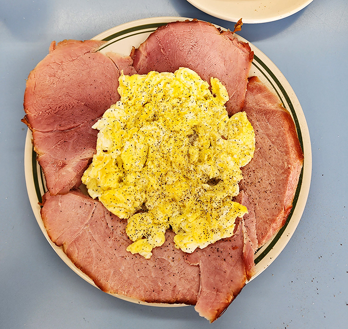 The famous ham and eggs breakfast presents like a sunflower&mdash;golden scrambled eggs surrounded by pink petals of thinly-sliced ham. Morning perfection on a plate.