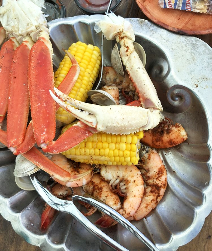 The ultimate seafood celebration &ndash; crab legs, shrimp, and corn on the cob. This metal platter holds more treasure than most pirate ships.