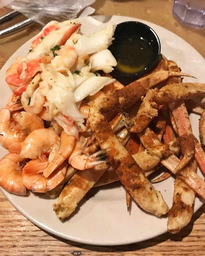 The seafood trifecta: succulent shrimp, seasoned crab legs, and butter for dipping. A plate that requires both napkins and your undivided attention.