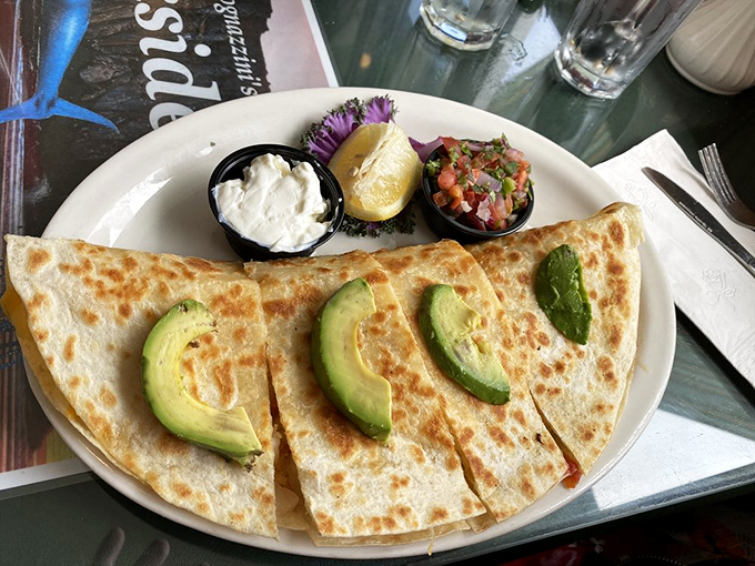 The seafood quesadilla arrives with perfect grill marks, sliced avocado, and sides of sour cream and salsa—California fusion that actually makes sense.