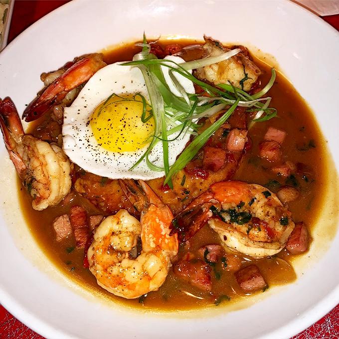 The shrimp and grits arrive like a Southern hug in a bowl, complete with a sunny-side-up egg that's practically winking at you.