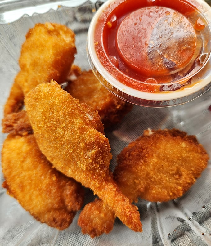 Golden-fried seafood bites paired with tangy cocktail sauce&mdash;proof that sometimes the simplest pleasures are the most satisfying.