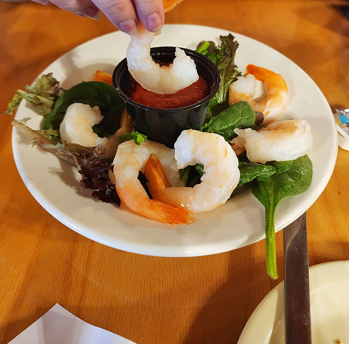 These shrimp are dressed to impress, circling a pool of zesty cocktail sauce. The lettuce? Just there for the fancy vibes.&rdquo;