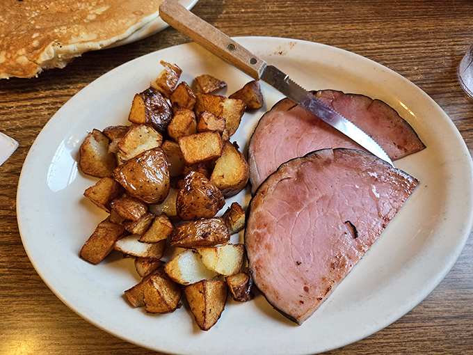 Home fries crisped to golden perfection alongside ham sliced thick enough to make a vegetarian reconsider their life choices.