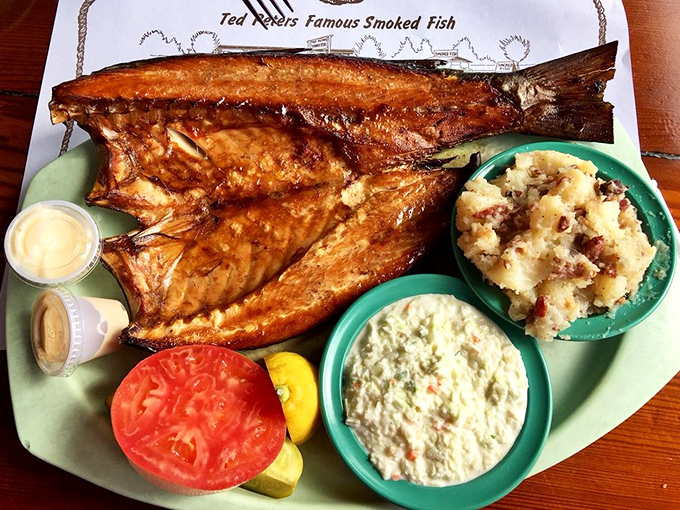 The whole smoked mullet arrives like seafood royalty, flanked by its loyal courtiers: German potato salad, coleslaw, and the requisite fresh garnishes. 