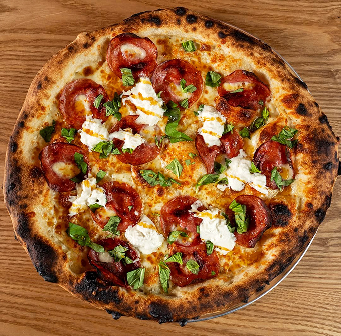 That crust tells stories of 48-hour fermentation, with air pockets that would make a sourdough baker weep with joy. Pizza architecture matters, folks.