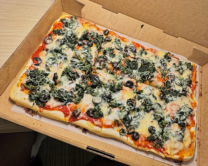 Old Forge pizza isn't round, and that's the point. This spinach-topped rectangular beauty makes geometry delicious in ways your math teacher never explained.