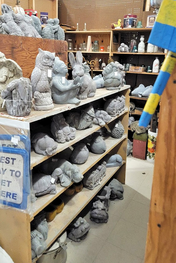 A menagerie of concrete creatures waiting for garden homes, like a stone zoo frozen in mid-conversation.