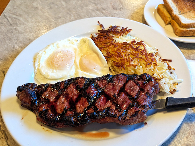 The classic steak and eggs&mdash;where a beautifully grilled New York strip meets sunny-side-up eggs and crispy hash browns in breakfast harmony.