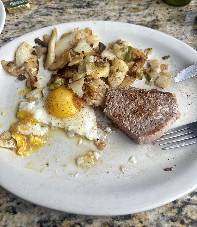 The classic steak and eggs, where a perfectly cooked piece of beef shares the spotlight with sunny-side up eggs and those legendary home fries.