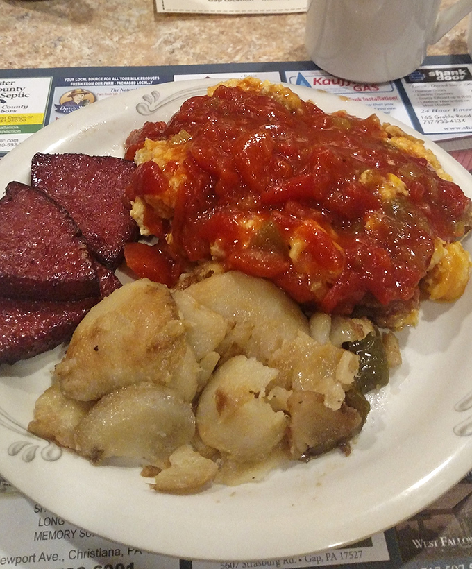 A plate that tells a story of Pennsylvania comfort&mdash;rich stewed tomatoes, potatoes, and what appears to be Lebanon bologna, a trio of regional favorites.