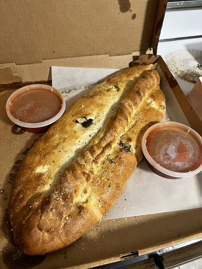Not just a calzone, but a work of art – golden-brown stromboli with marinara dipping sauce that makes sharing nearly impossible.