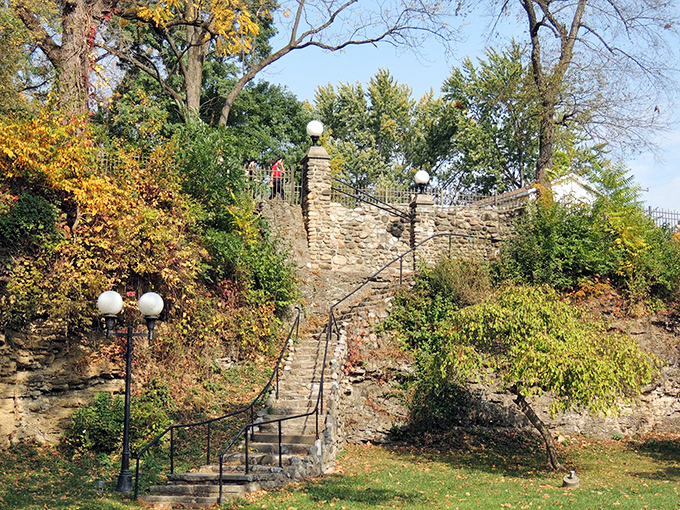 Stone steps wind upward through this enchanting garden overlook, where globe lamps stand sentinel like something from a vintage fairytale.