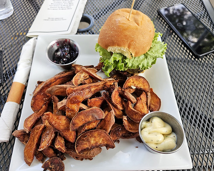 A burger that knows its purpose in life, surrounded by sweet potato fries that achieve that mythical balance between crispy exterior and pillowy interior.