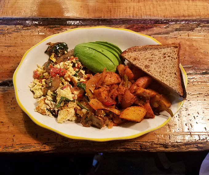 A plate that proves vegetables can party too &ndash; vibrant tofu scramble with roasted potatoes and avocado slices that might make you forget eggs ever existed.