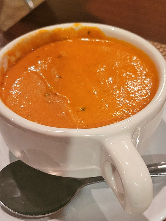 A tomato soup so vibrant it looks like liquid sunshine, promising the kind of warmth that starts in your stomach and radiates outward.