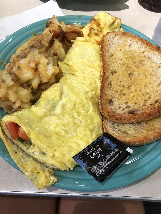This isn't just an omelet&mdash;it's a fluffy yellow pillow of morning happiness alongside those famous lyonnaise potatoes that could steal the spotlight.