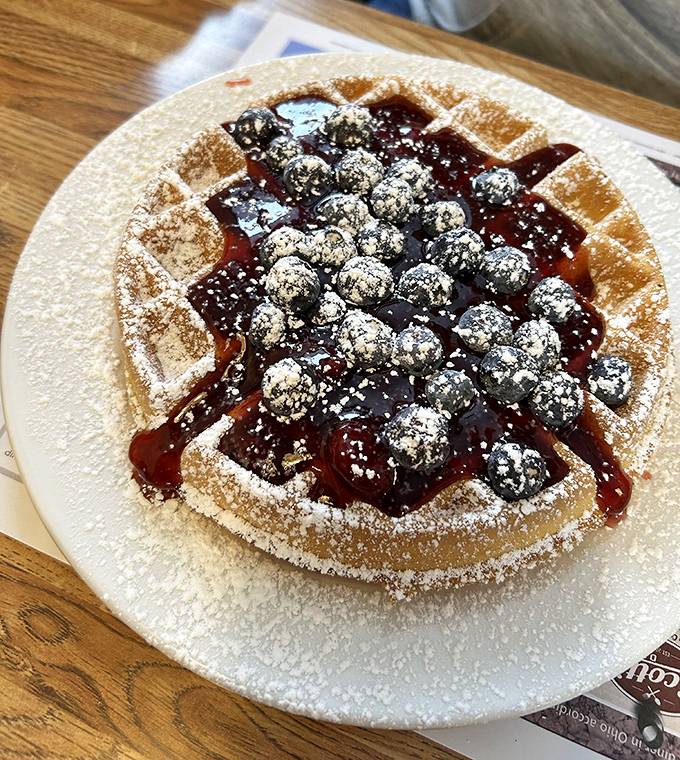 A waffle that deserves its own ZIP code, topped with fresh blueberries and powdered sugar. Breakfast or dessert? Why choose when you can have both?