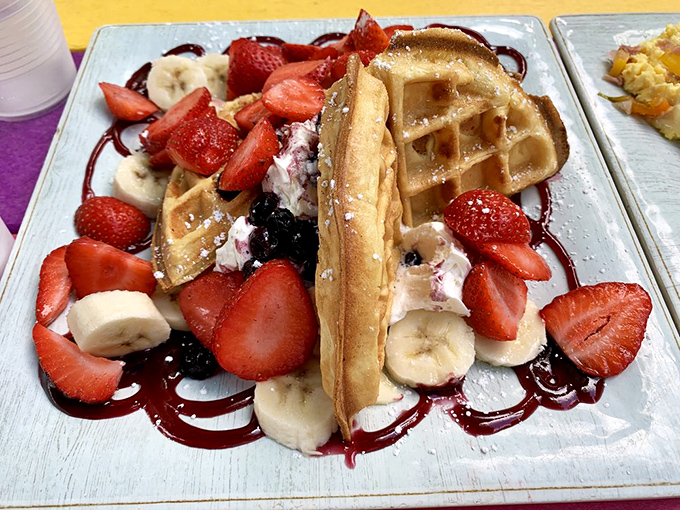 This isn't just a waffle&mdash;it's a fruit-laden masterpiece where strawberries, bananas and blackberries compete for your attention like performers in a delicious circus.