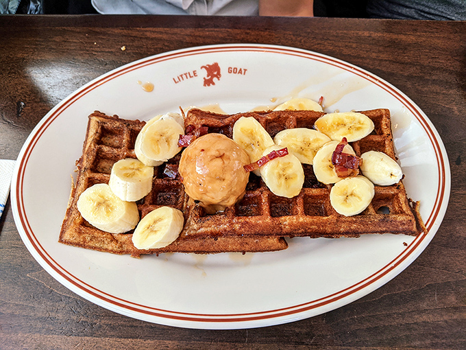 Breakfast royalty arrives on a throne of waffle, crowned with banana slices and what appears to be a perfect scoop of peanut butter.